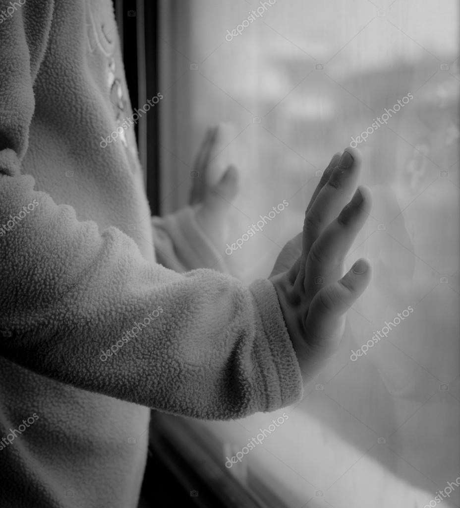 Child looking through the window with hands laid on the glass Stock ...