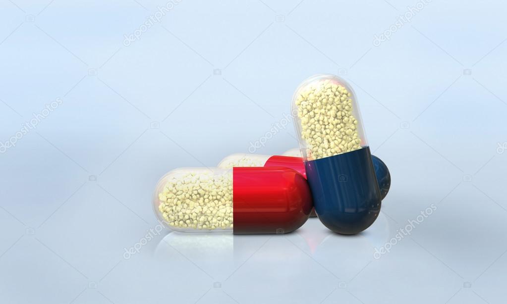 Tres cápsulas de medicamentos sobre fondo azul 2023