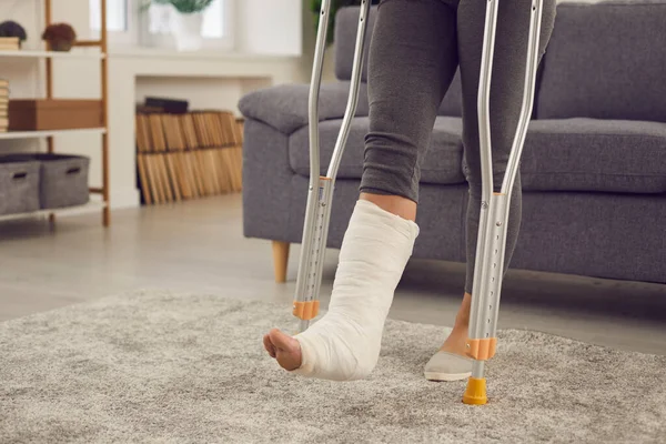 Crutches and a broken leg in a plaster bandage of an unknown person ...
