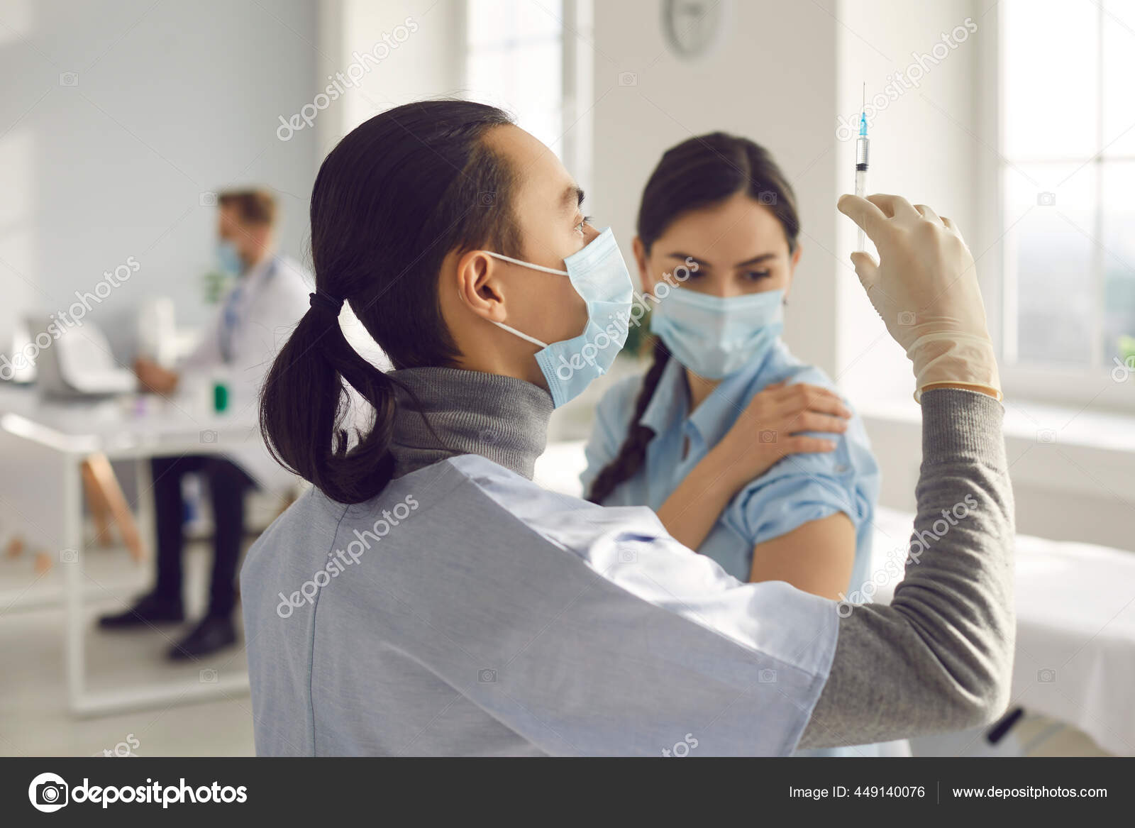 Doctor holding a syringe with medication releasing a stream of ...