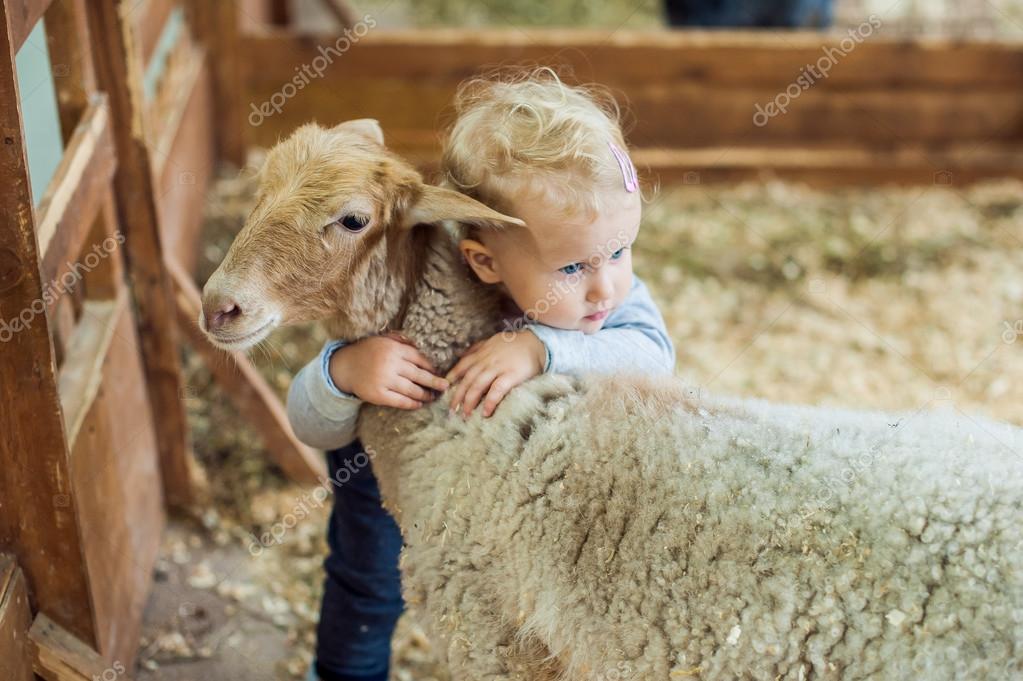 Girl hugging lamb — Stock Photo © galitskaya #118267464