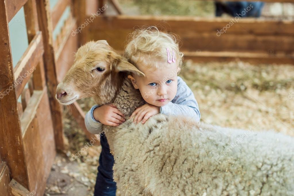Girl hugging lamb — Stock Photo © galitskaya #118267730
