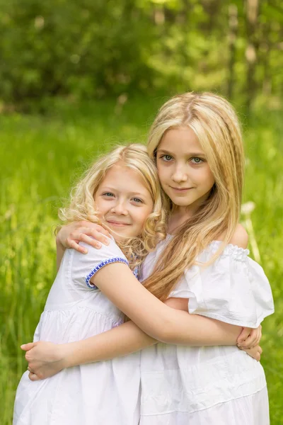 Two young children standing outdoors holding hands smiling — Stock ...