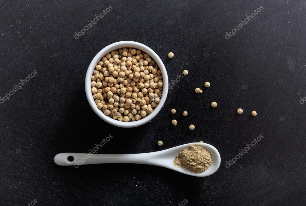 White pepper seeds and powder in porcelain bowl and spoon — Stock Photo ...