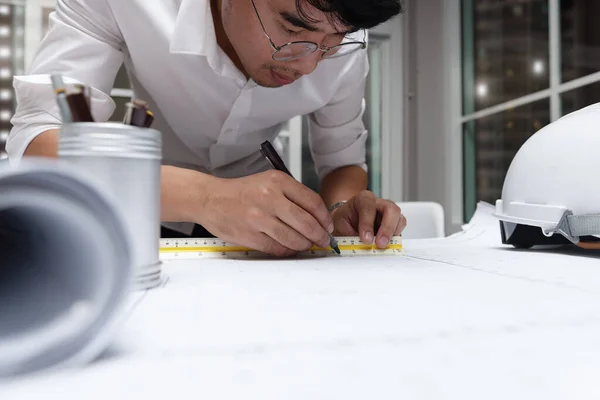 Ingeniero Diseñador de bocetos con Blueprint Architecture en la oficina de escritorio en casa ...