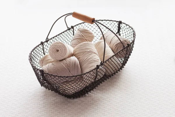 Handmade macrame braiding and cotton threads in basket on white ...