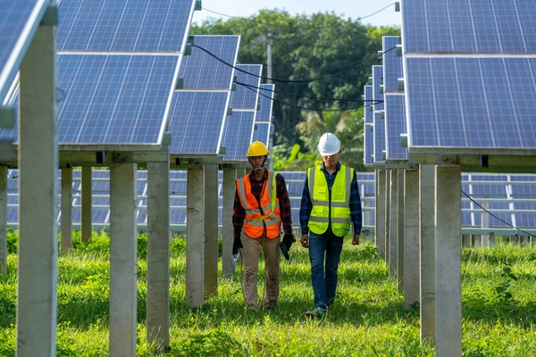 Engineer and electrician inspect solar panel at solar power plant ...