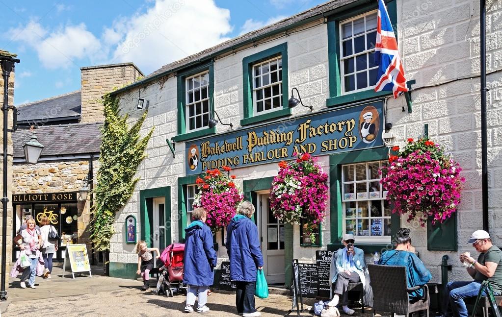 Tourists sitting at a pavement cafe outside the Bakewell pudding ...