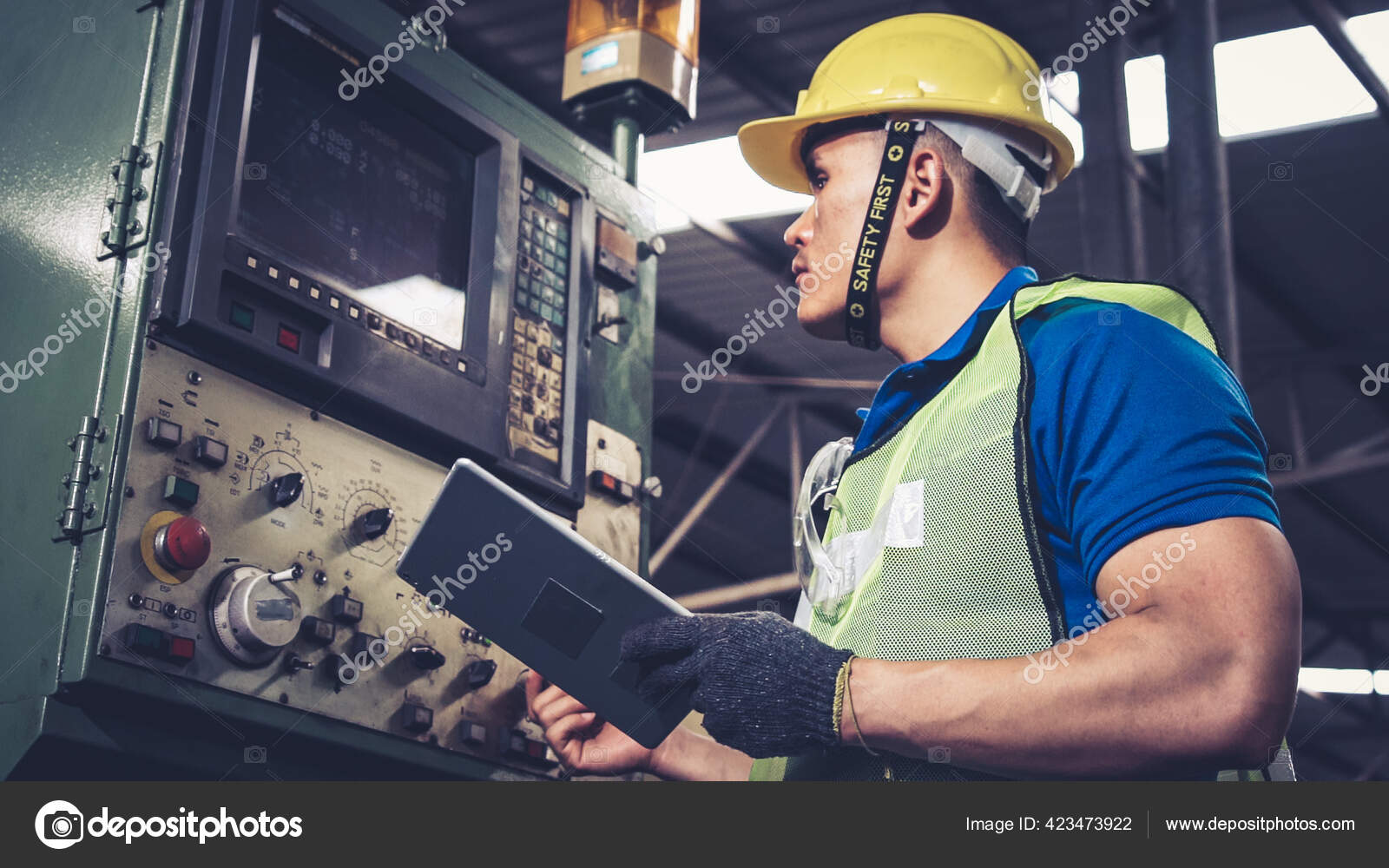 Smart factory worker using machine in factory workshop Stock Photo by ...