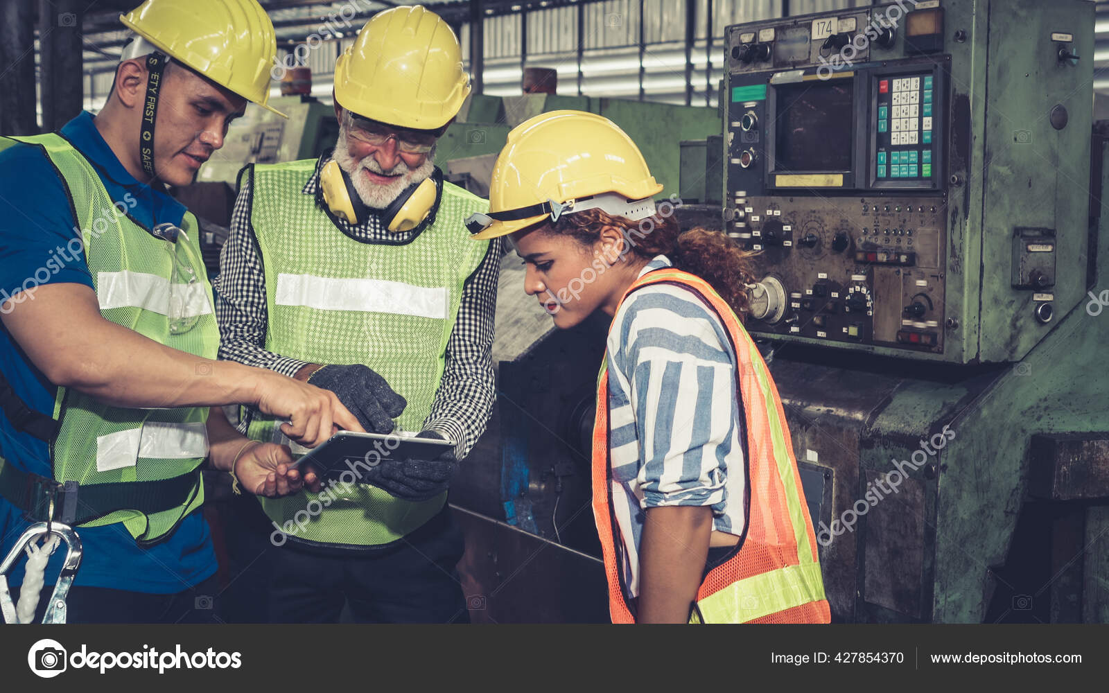 Group of factory workers using machine equipment in factory workshop ...